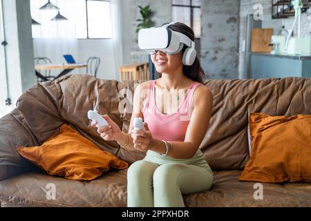 Asian woman play video game with headphones and controller relax on ...