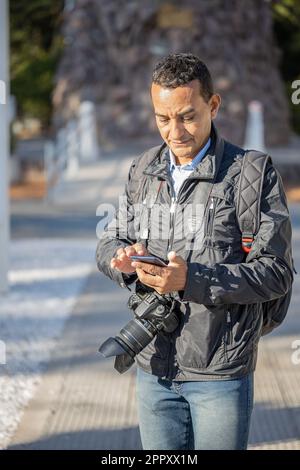 Young hispanic man reporter working using microphone at street Stock ...