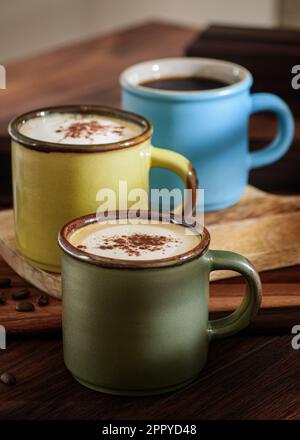 Cups of fresh coffee and a classic coffee maker on white table Stock ...