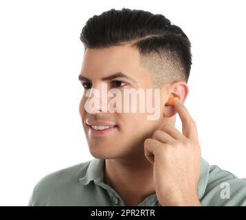 Man inserting foam ear plug on white background Stock Photo - Alamy