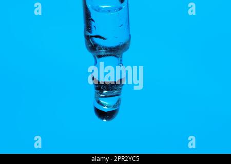 Dripping face serum from pipette on white background, closeup. Space ...