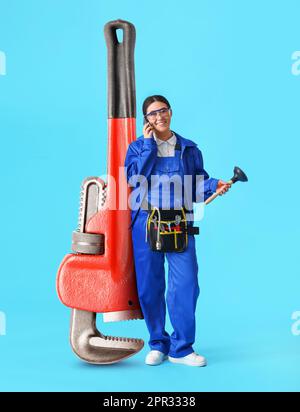 Asian female plumber with pipe wrench in kitchen Stock Photo - Alamy