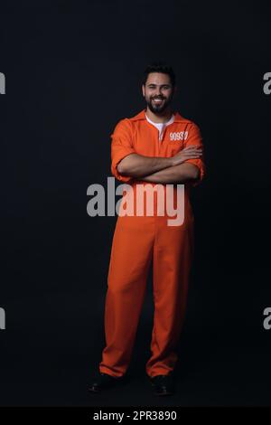 Happy prisoner in jumpsuit on black background Stock Photo - Alamy