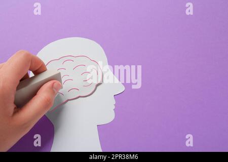 Woman erasing brain on human head paper cutout on violet background ...