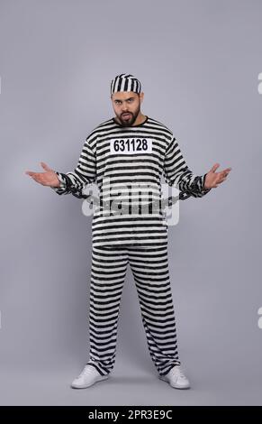 Prisoner in special uniform with chained hands on grey background Stock ...