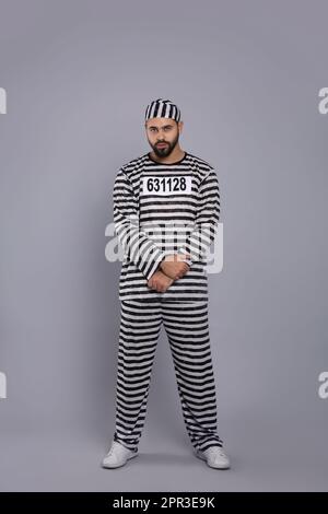 Prisoner in special uniform on grey background, space for text Stock ...