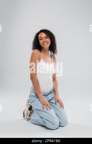 Nude slender woman sitting on her haunches Stock Photo - Alamy