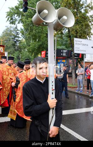 Young man orthodox monk bringing golden cross on the street. Ukrainian ...
