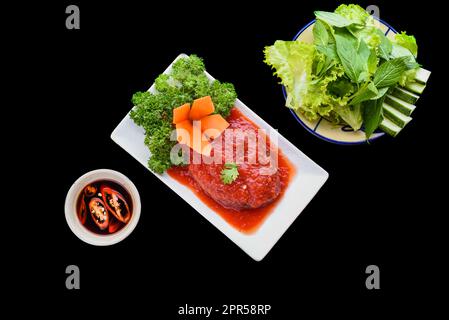 Vietnamese stewed sapa fish in red sauce isolated on black bacground ...