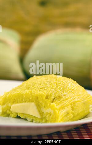 Pamonha, a traditional brazilian corn cake, served on glass plate over ...