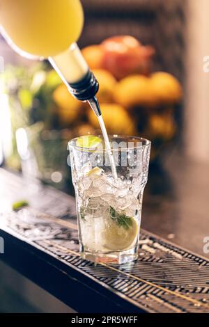 Bartender pouring syrup into cocktail with ice on white background ...