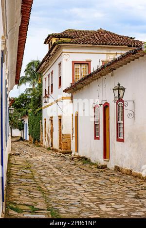 Bucolic street with old colonial-style houses and cobblestone pavement ...