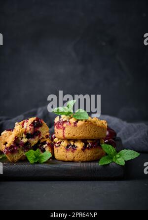 Portion crumble pie with cherries on a wooden board decorated with ...