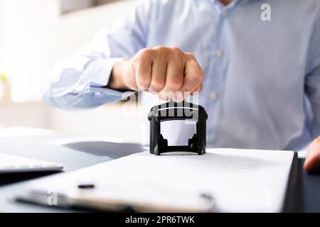 Person's Hand Stamping With Approved Stamp Stock Photo - Alamy