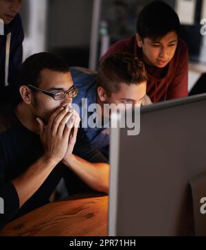 This is insane. Shot of a group of young designers staring tensely at a ...