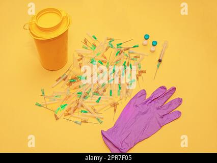 Bunch of used needles for medical waste with syringe and surgical glove ...