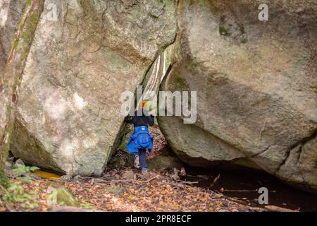 A person walking between two large boulders Stock Photo - Alamy