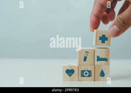 Hand put wooden cubes with insurance health care medical symbol on ...