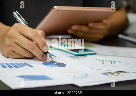Businessman holding pen document graph accounting finance paper work ...