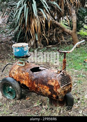 An old rusty tank stands in the middle of thick grass near the seashore ...