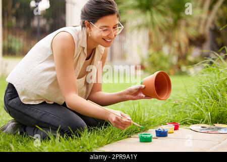 Creativity is just connecting things. s young woman painting a pot in ...