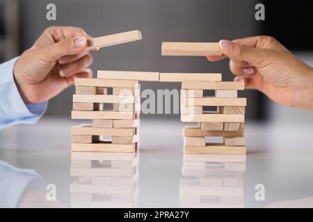 Woman building bridge with wooden blocks on light blue background, top ...