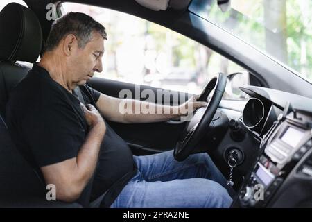 Senior behind the steering wheel with chest pain Stock Photo - Alamy