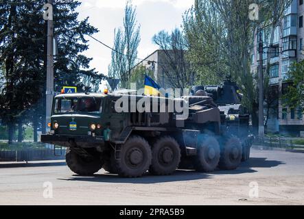 A Ukrainian army truck carries a self-propelled howitzer, a wheeled ...