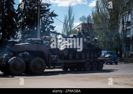 A Ukrainian army truck carries a self-propelled howitzer, a wheeled ...
