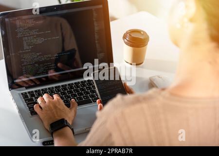 Programmer woman looking mobile phone program code at workplace ...