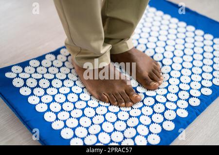 Acupressure Mat And Acupuncture Body Care Equipment. Male Feet Stock ...