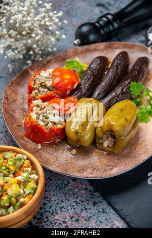 front view delicious vegetable dolma with salad and tomatoes on blue ...