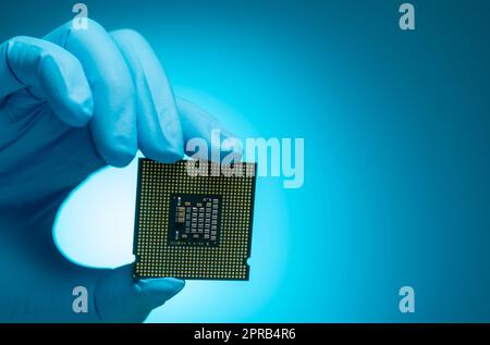 Electronic engineer hand holding computer chip on blue background ...
