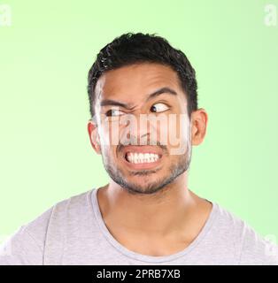 Showing a little grit. a handsome young man making a face against a ...