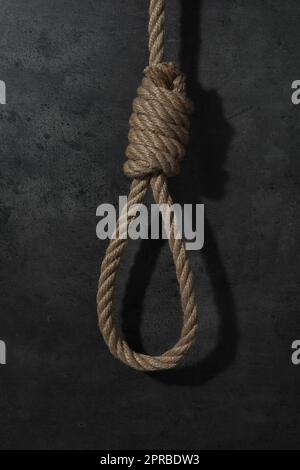Tied rope noose against grey stone background Stock Photo - Alamy
