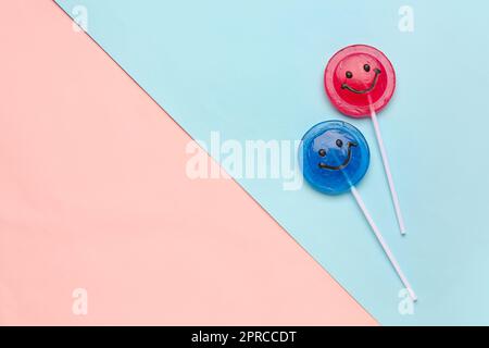 Red and blue lollipops with smiles on colorful background Stock Photo ...