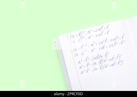 Copybook with maths formulas on green background Stock Photo - Alamy