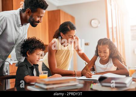 Getting homework done before playtime. parents helping their two ...