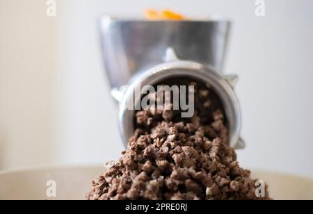 Minced meat in a manual mechanical meat grinder. Fresh boiled meat is ...