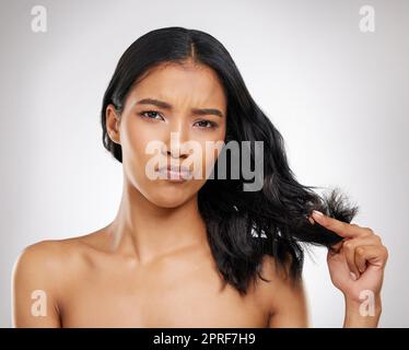 Its time for a trim. a young woman sulking while holding up her ends ...