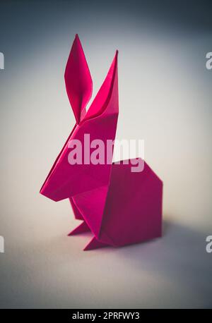 Pink paper rabbit origami isolated on a blank grey background Stock ...