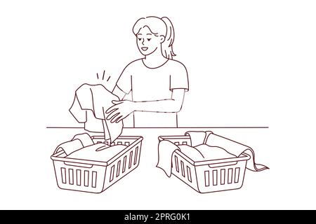 Woman sorting dirty clothes for washing. Girl gathering laundry in ...
