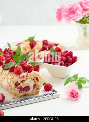Meringue roll cake with cream on wooden table Stock Photo - Alamy