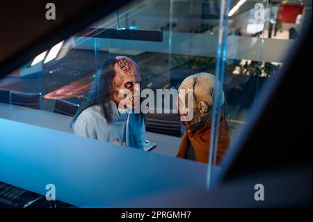Ugly zombie monster employees in night office boardroom overhead view ...