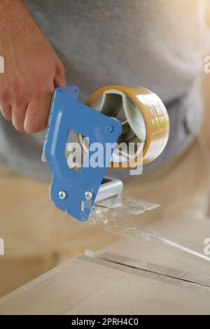 man closing a cardboard box with tape at home Stock Photo - Alamy