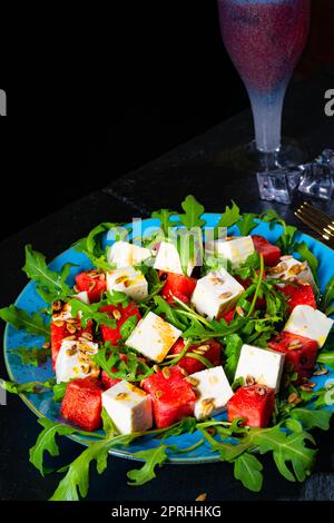 Melon salad, yellow watermelon, feta, mint and rocket on plate Stock ...
