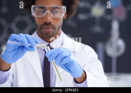 Mixing things up. a male scientist conducting an experiment in his lab ...