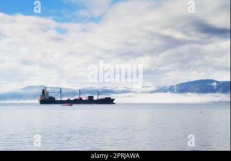 Carrying valuable cargo. A freight ship travelling along the coast line ...
