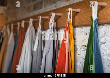 Selective focus on colourful fabrics hanging on hanger on brick wall ...