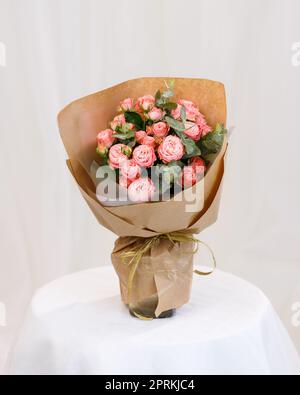 Pink spray roses with sprigs of green eucalyptus stacked together in ...